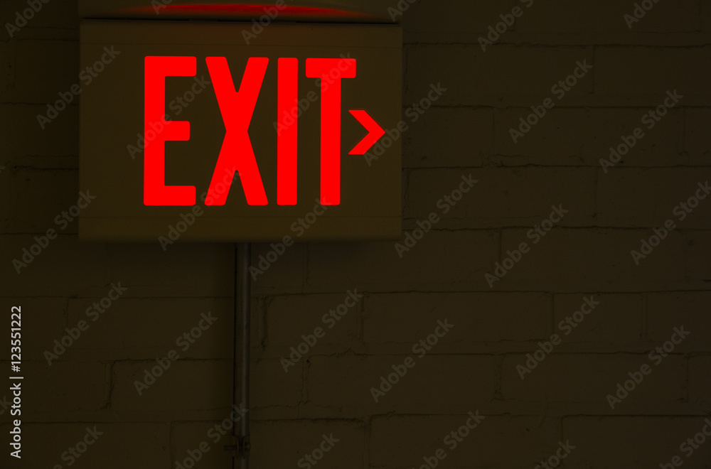 red emergency exit sign in the dark room. illuminated office exit sign ...