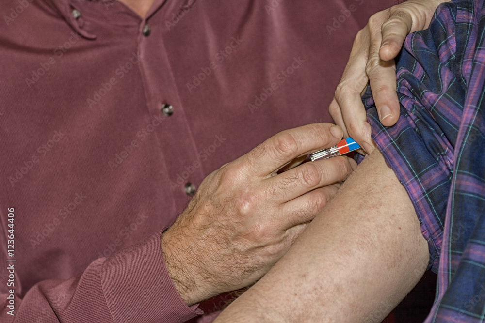 Foto Stock Doctor gives injection in male arm | Adobe Stock
