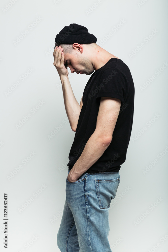 Side view of thoughtful man with his arm on his forehead. Studio shot ...