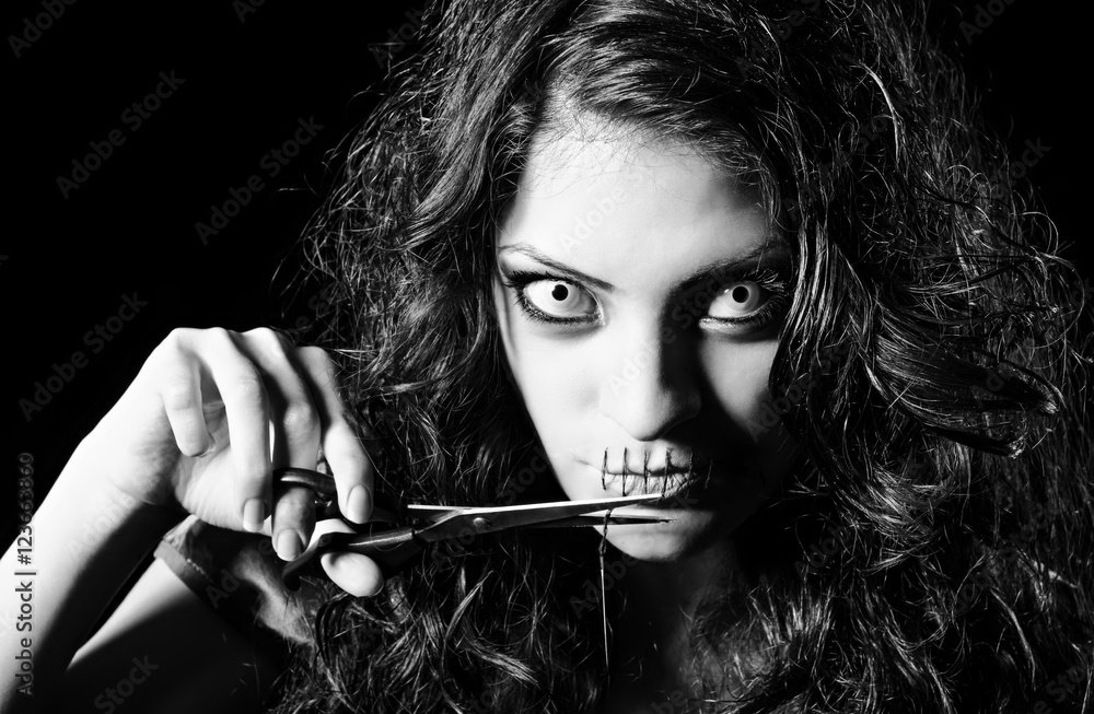 Horror shot: scary strange girl with mouth sewn shut cutting off the ...