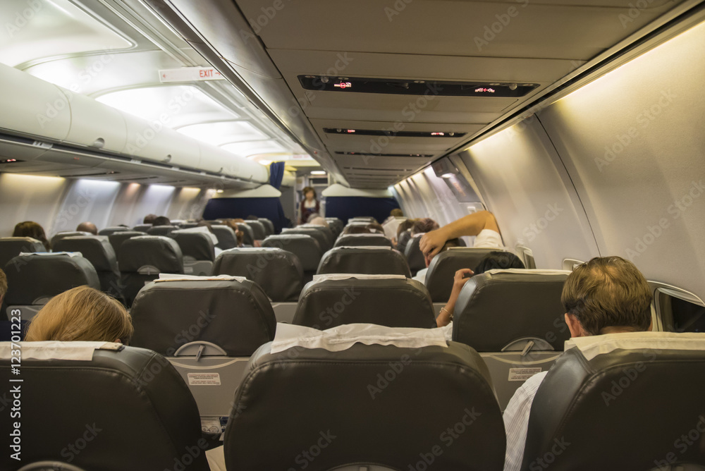Interior of airplane with passengers on seats waiting to taik off ...