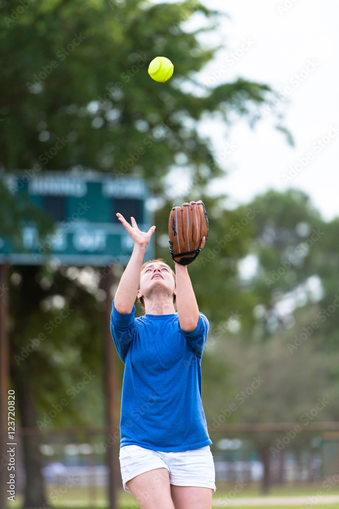 Young woman softball player catching ball Stock Photo | Adobe Stock