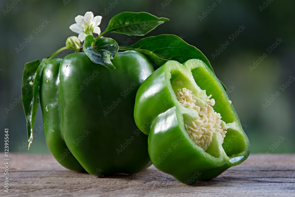 Big green whole and sliced bell pepper on the wooden table. Fresh ...