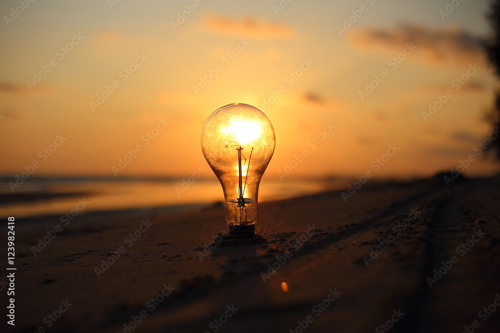 electric light bulb and sun at beach sunset sky Stock Photo | Adobe Stock