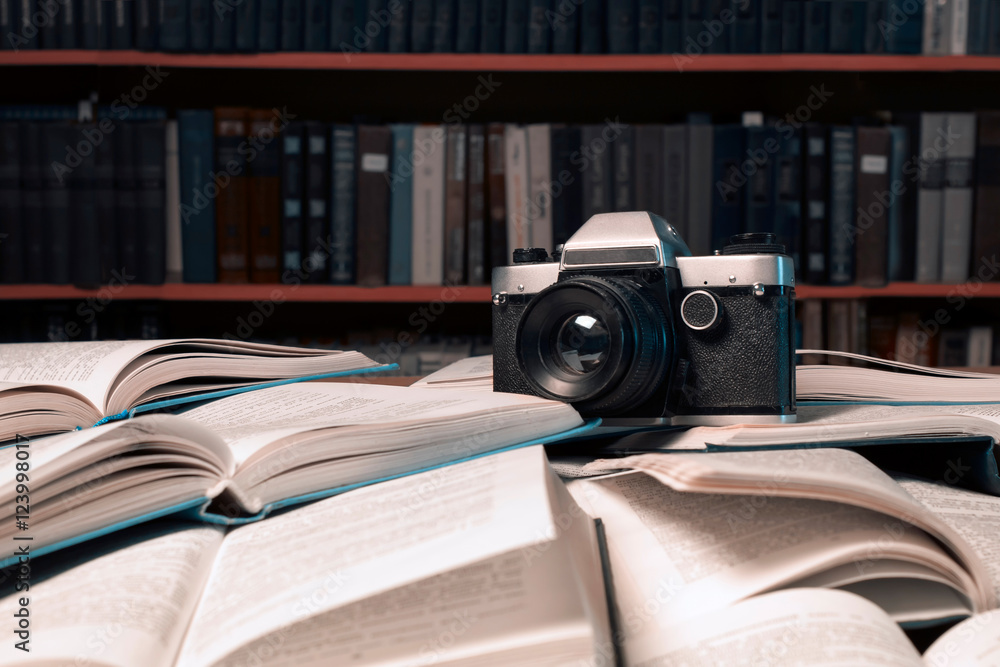 Old photo camera is on many open books piled up with many book Stock ...