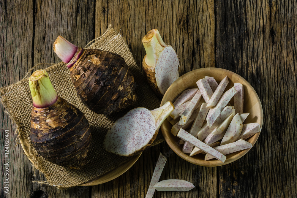 Taro dish on the table in the old wood.Taro is a plant commonly used in ...