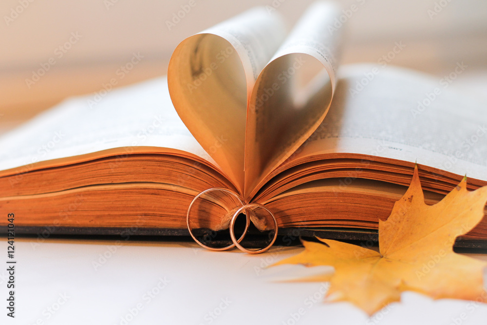 Open book with gold wedding rings and maple leaves. Wedding card with ...