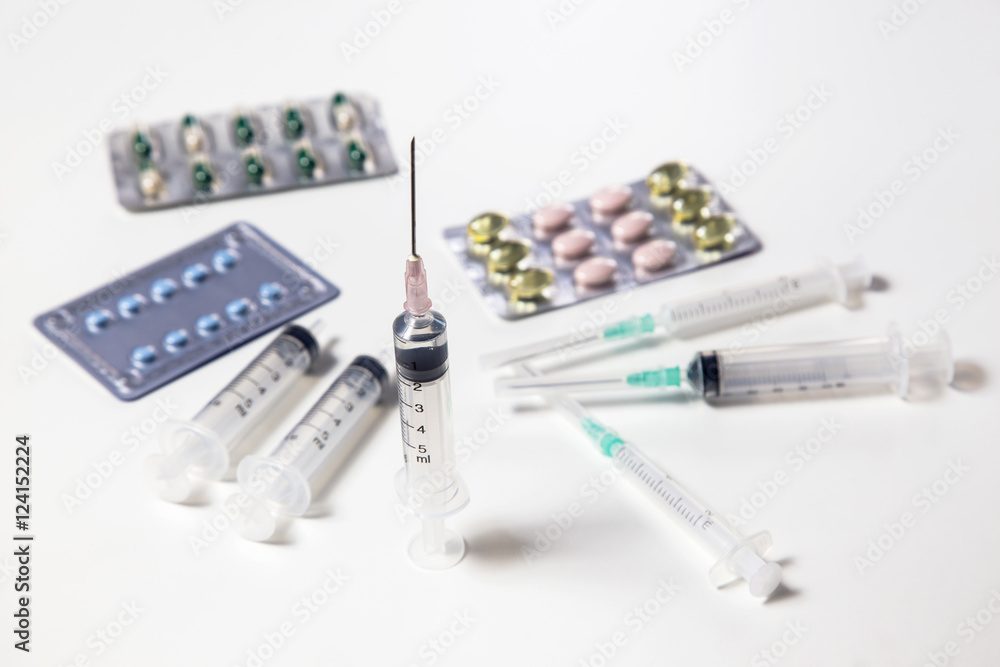 Medicine pills or capsules with syringe on white background. Drug ...