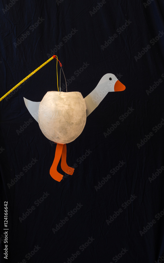 Gebastelte Martinslaterne in Form einer Gans vor dunklem Hintergrund ...