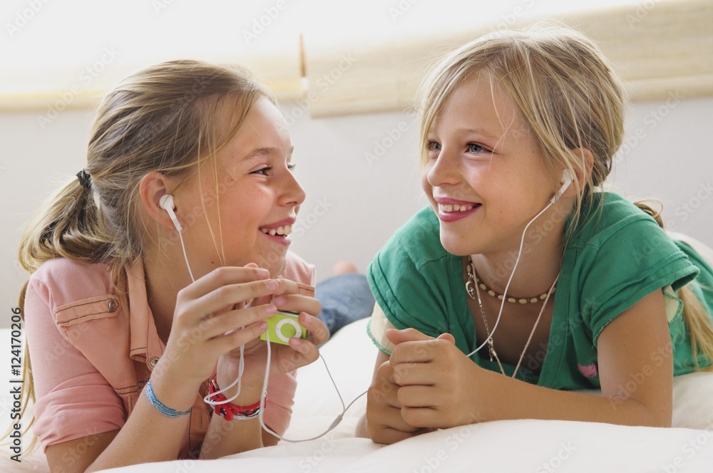 Two Girls Listening To Music Player Stock Photo | Adobe Stock