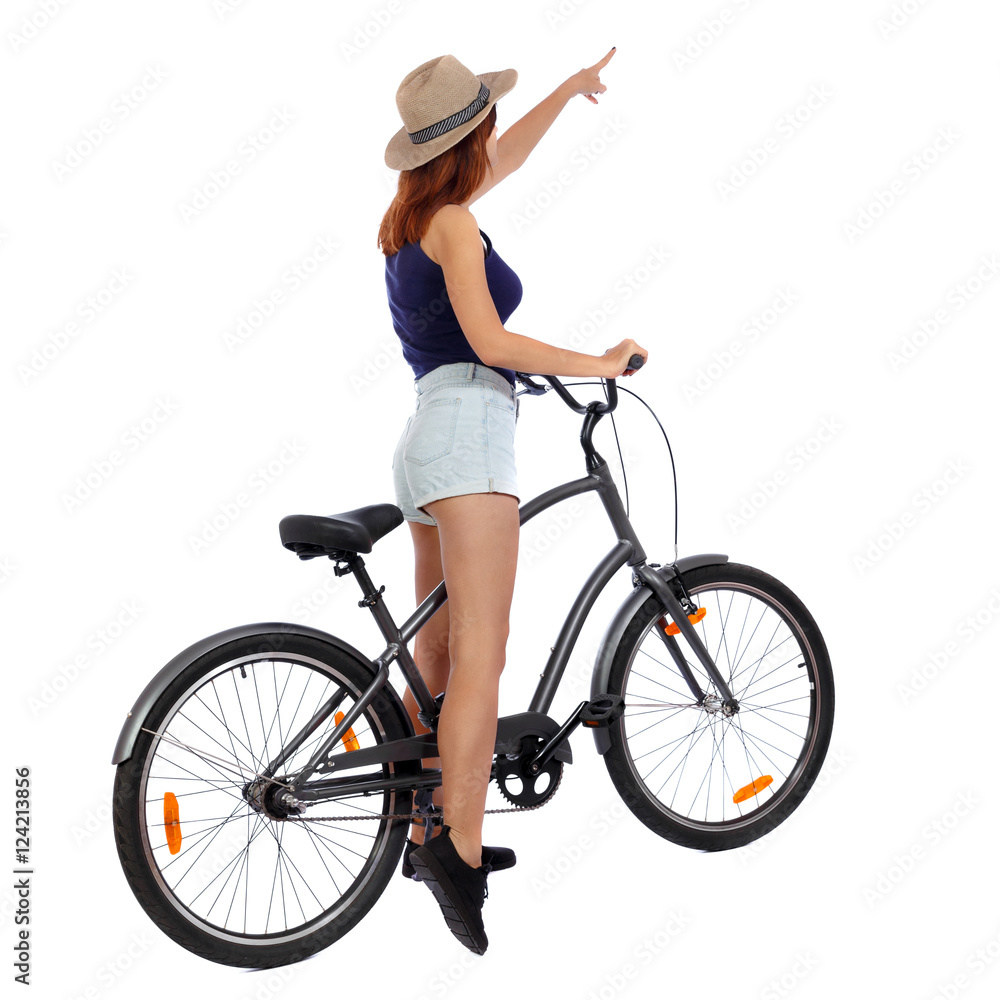 back view of pointing woman with a bicycle. cyclist sits on the bike ...