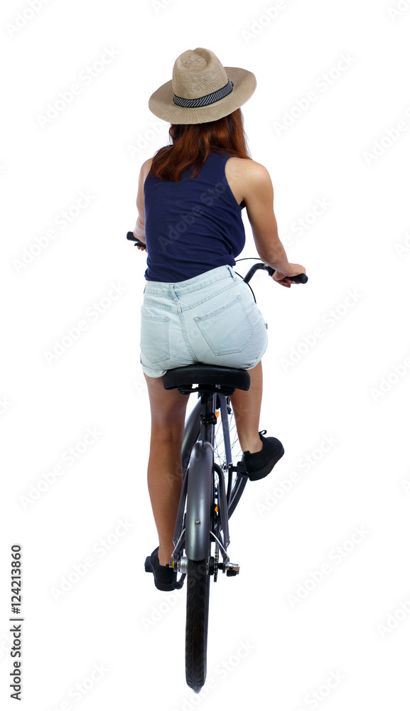 back view of a woman with a bicycle. cyclist sits on the bike. Rear ...