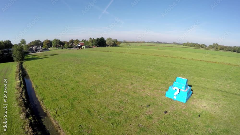 Aerial of white question mark on small bright blue structure drone ...