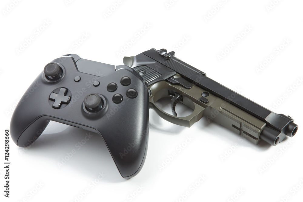 Game controller and a real handgun near it - studio shot. Virtual and ...