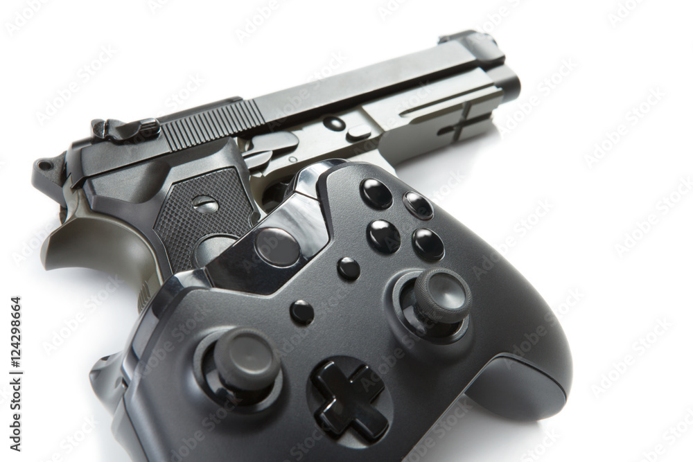 Game controller over a real handgun - studio close up shot. Virtual and ...