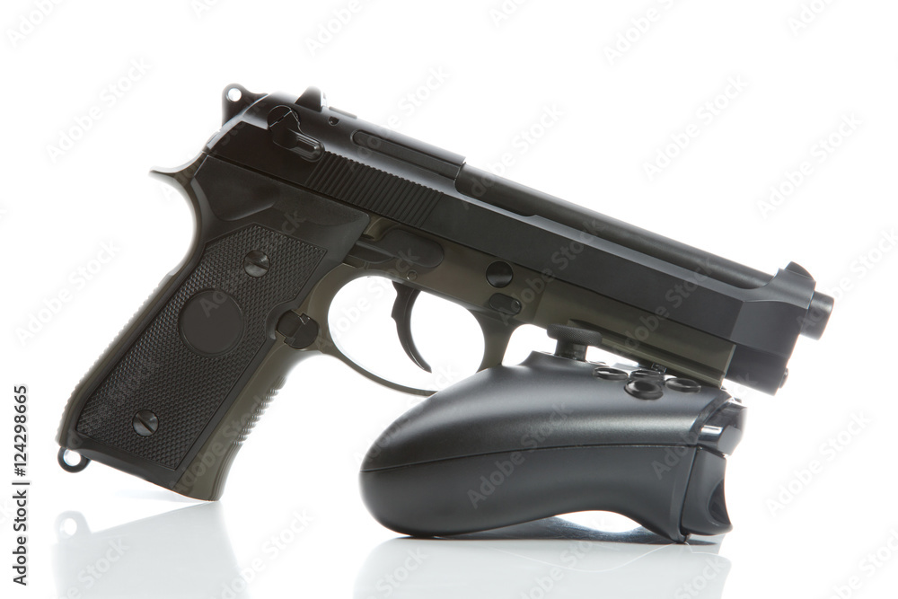 Hand gun over game controller - studio close up shot. Virtual and real ...