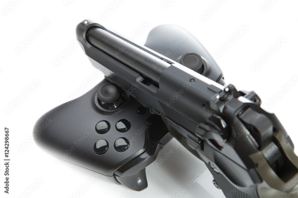 Game controller and a real handgun - studio close up shot. Virtual and ...