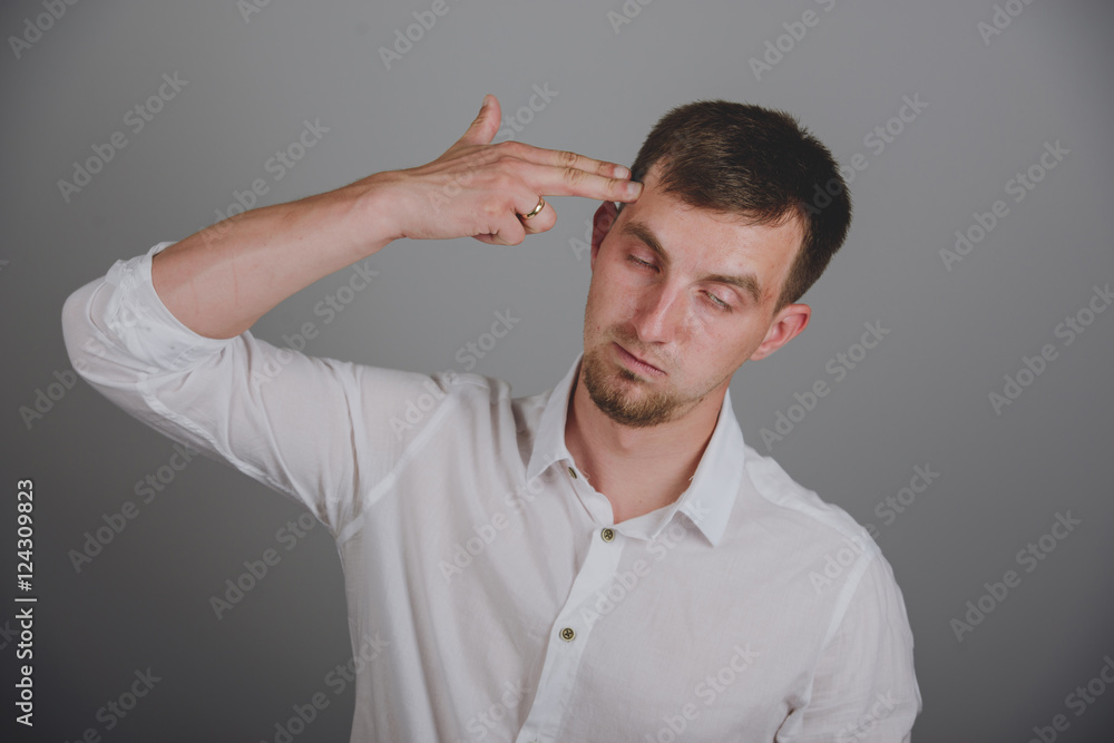 young man pointing finger gun gesture to head Photos | Adobe Stock