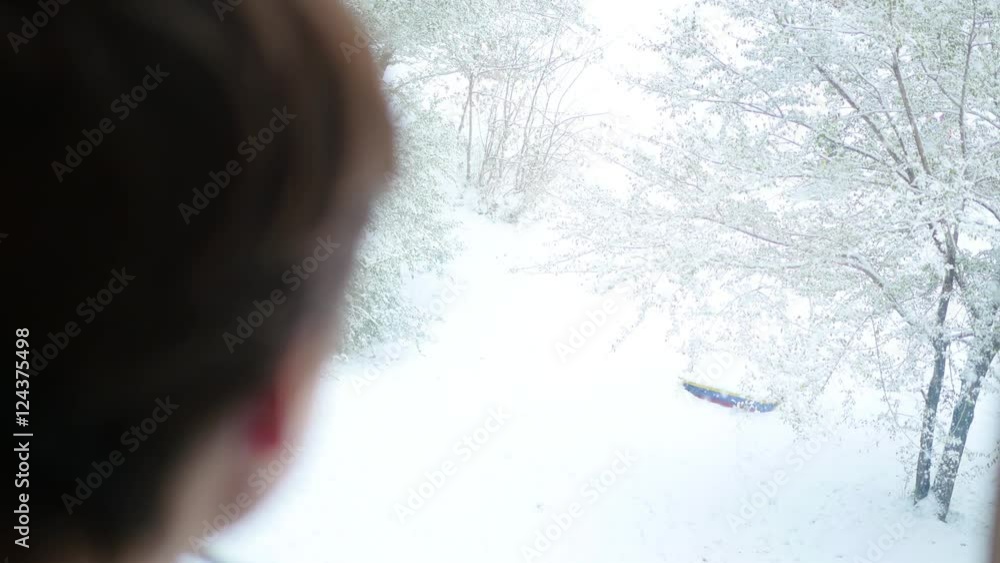 a guy looks out the window at the snowfall Stock Video | Adobe Stock