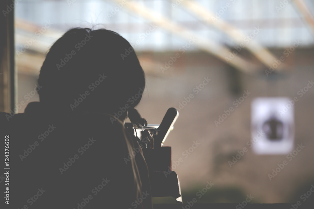 Man is shooting a long rifle to human shooting target.(Processed in ...