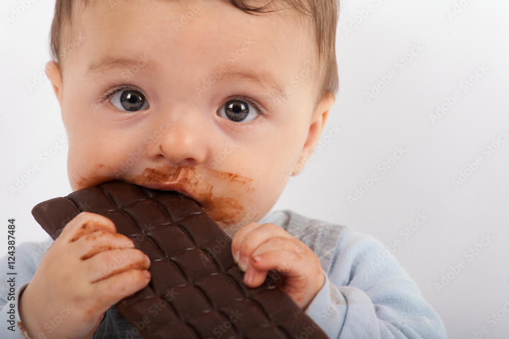 Portrait of an adorable baby eating chocolate Stock Photo | Adobe Stock