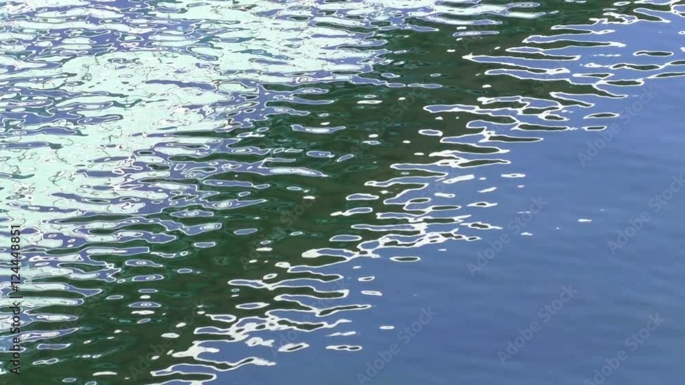 Florid reflections on a clear wavy water surface. Colorful liquid ...