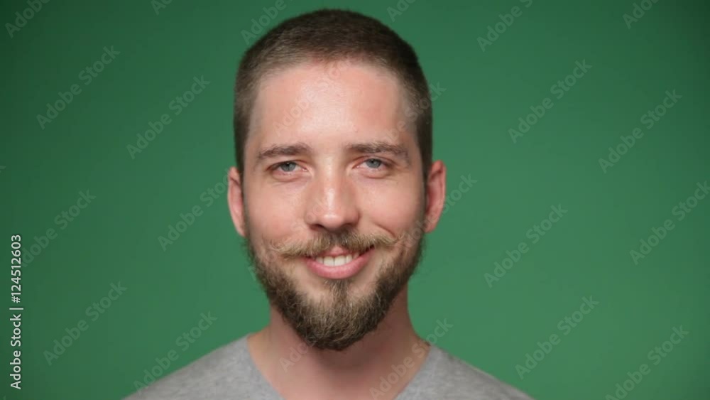 Close up young hipster man tightening up mustache and smiling, chroma ...