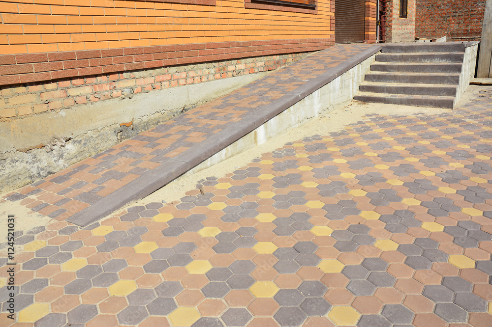 Building ramp for wheelchair entry and stairs with colorful pavers ...