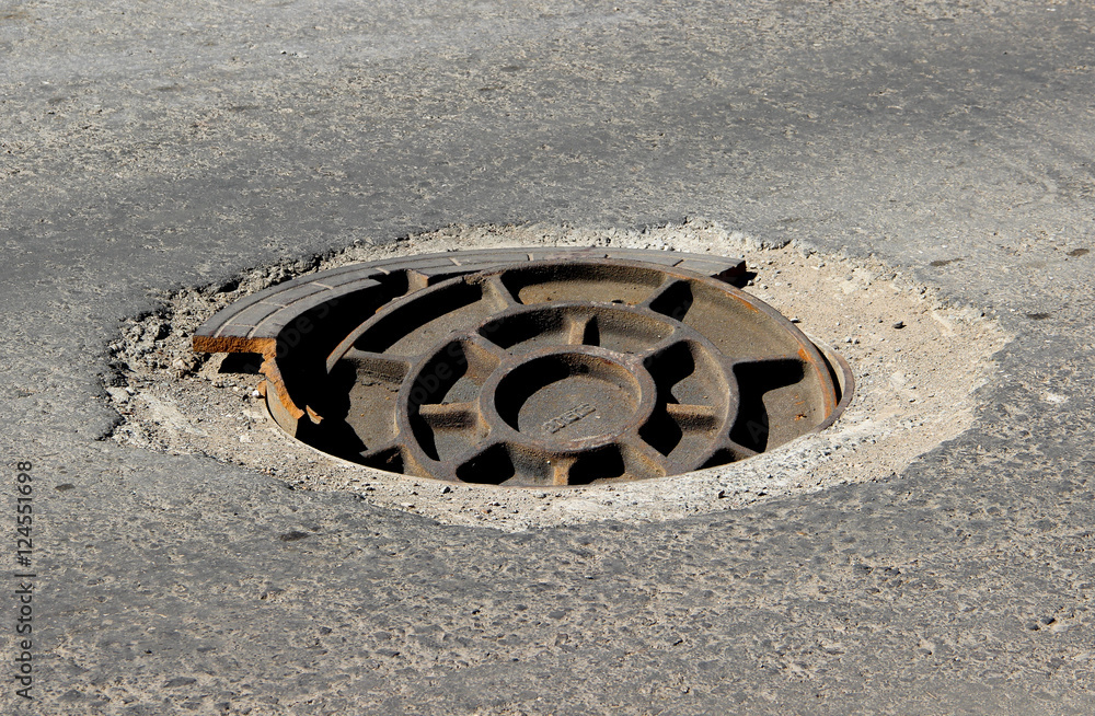 Damaged manhole cover in a city street Stock Photo | Adobe Stock