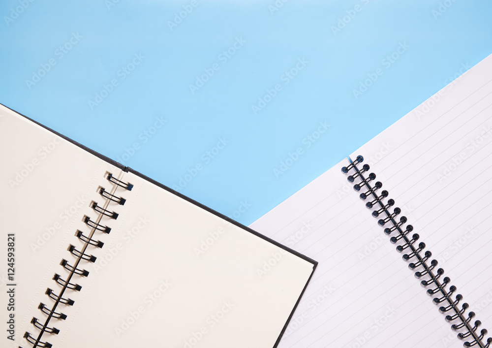 Open notebooks on a bright blue background forming a homework themed ...