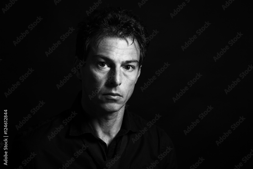 Man low key high-contrast profile portrait in backlight with a serious ...