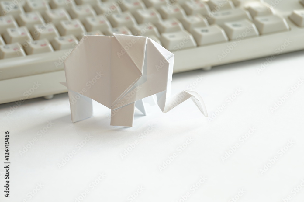 Paper origami elephant isolated on white background on the table next ...