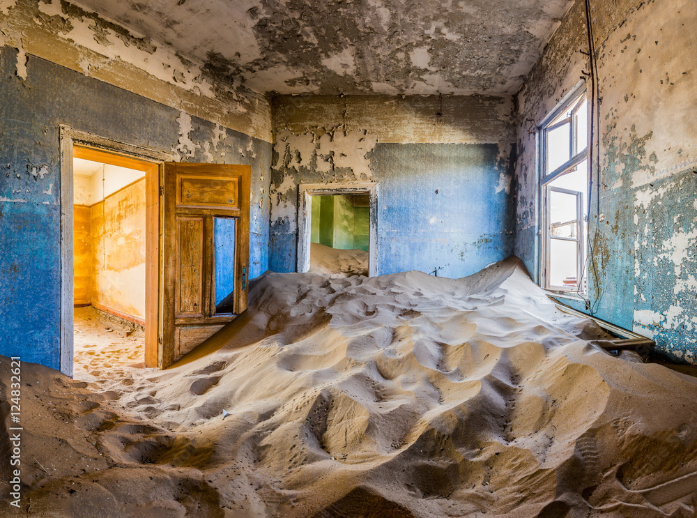 Room full of sand with colored door in the ghost town of Kolmanskop ...