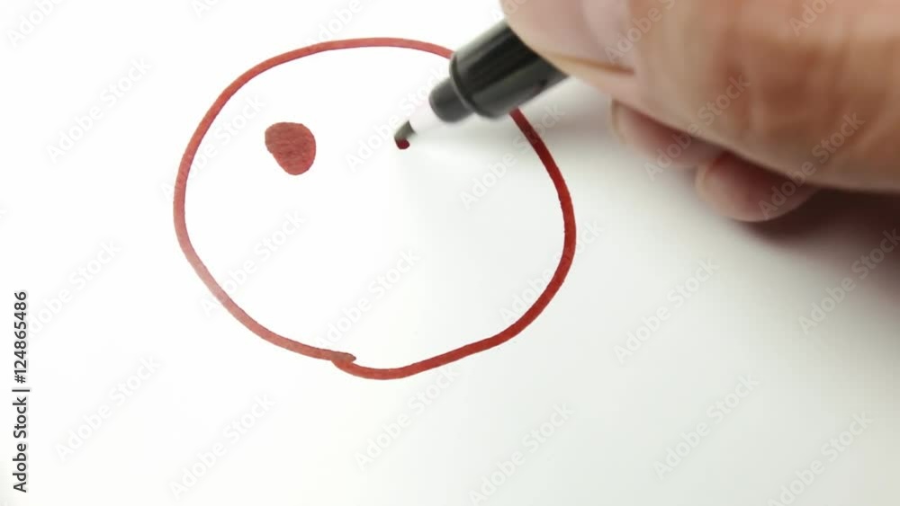 Hand-drawing a smiley (emoticon) and the text Smile on a sheet of paper ...
