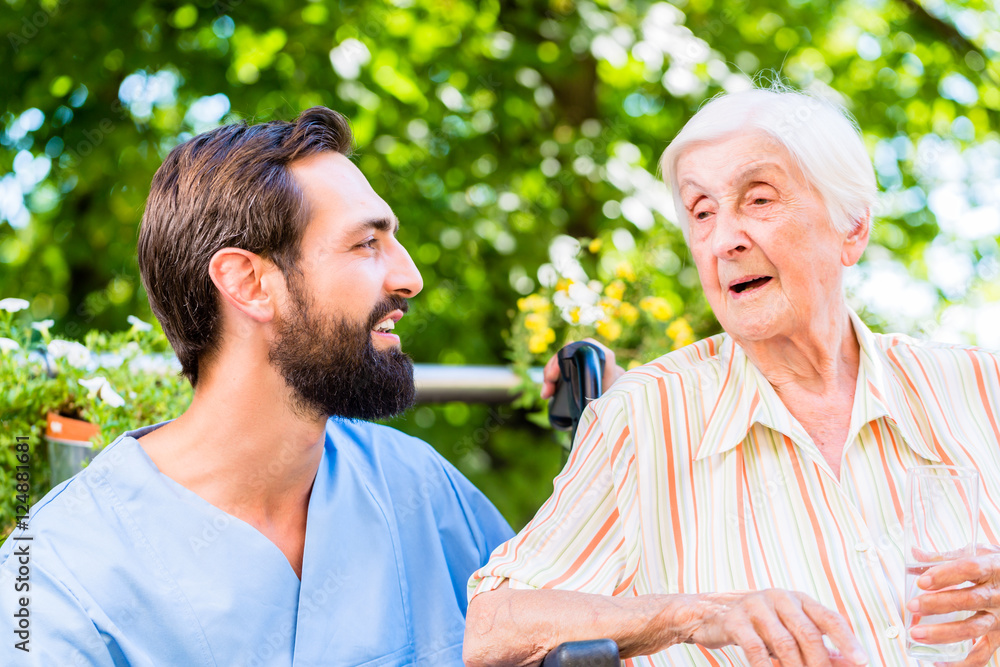 Altenpfleger unterhält sich mit Seniorin im Heim Stock-Foto | Adobe Stock