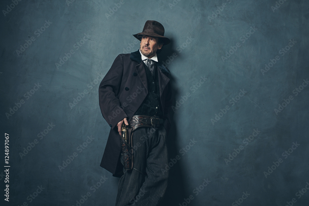 Mysterious mature retro 1900 western man standing against gray w Stock ...