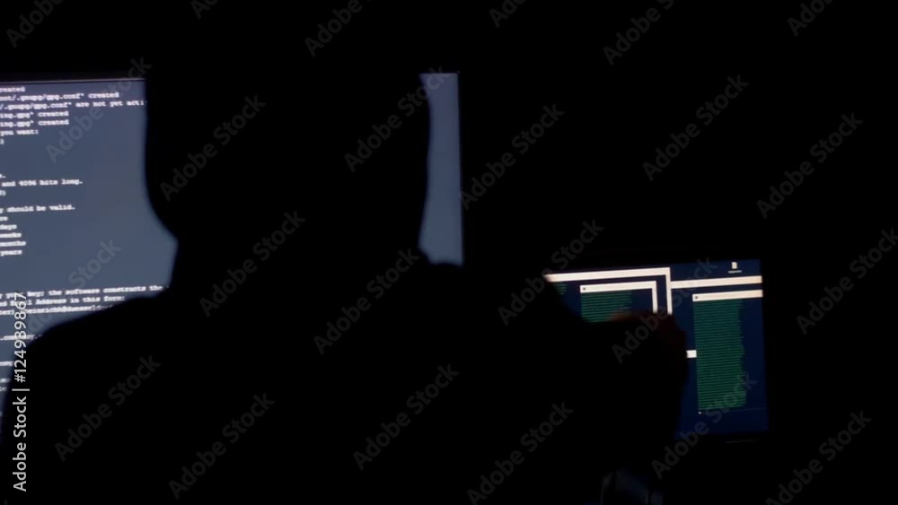 Hacker in hood cracking code using computers in dark room vídeo de ...