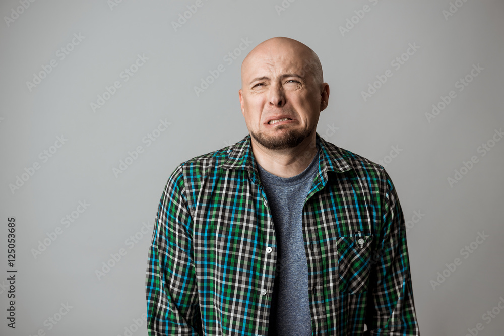 Resentful sad emotive man in shirt posing over beige background. Stock ...
