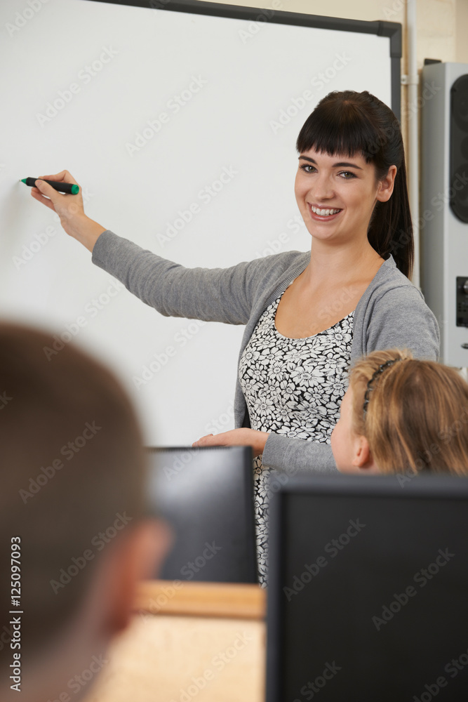 Teacher Writing On Interactive Whiteboard In Computer Lesson Stock ...