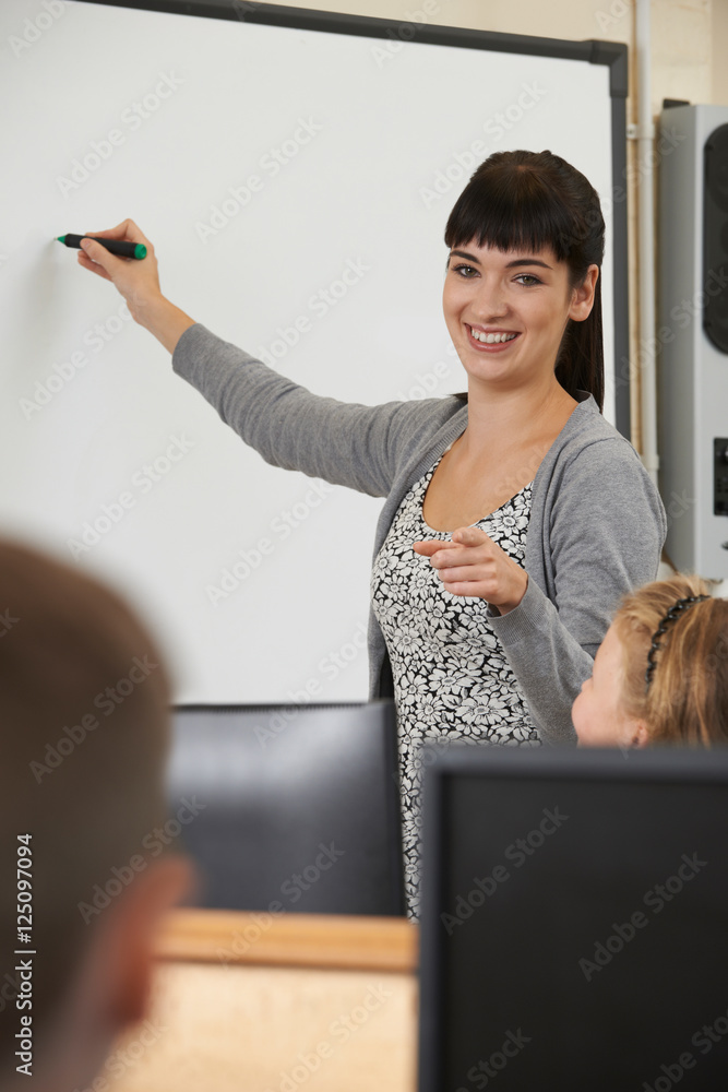 Teacher Writing On Interactive Whiteboard In Computer Lesson Stock ...