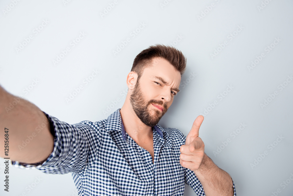 Young handsome man winking and pointing on camera while making s Stock ...
