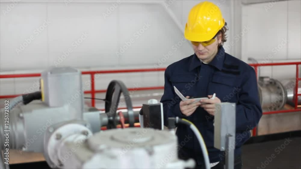 Man working in a factory, controls the operation of devices in a power ...