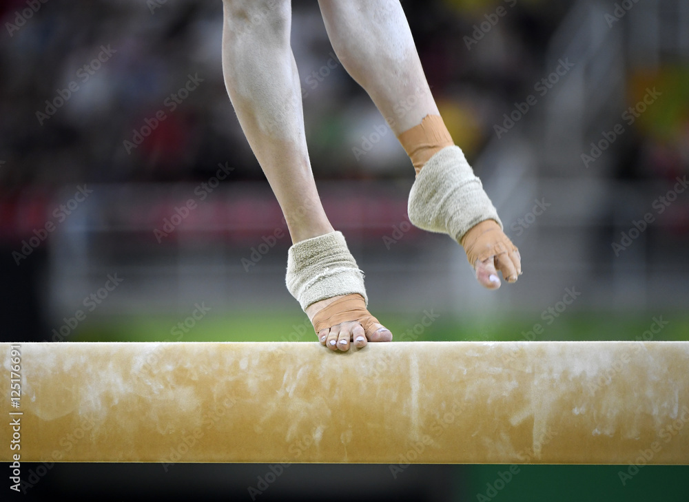 Female gymnast on balance beam during competition Stock Photo | Adobe Stock
