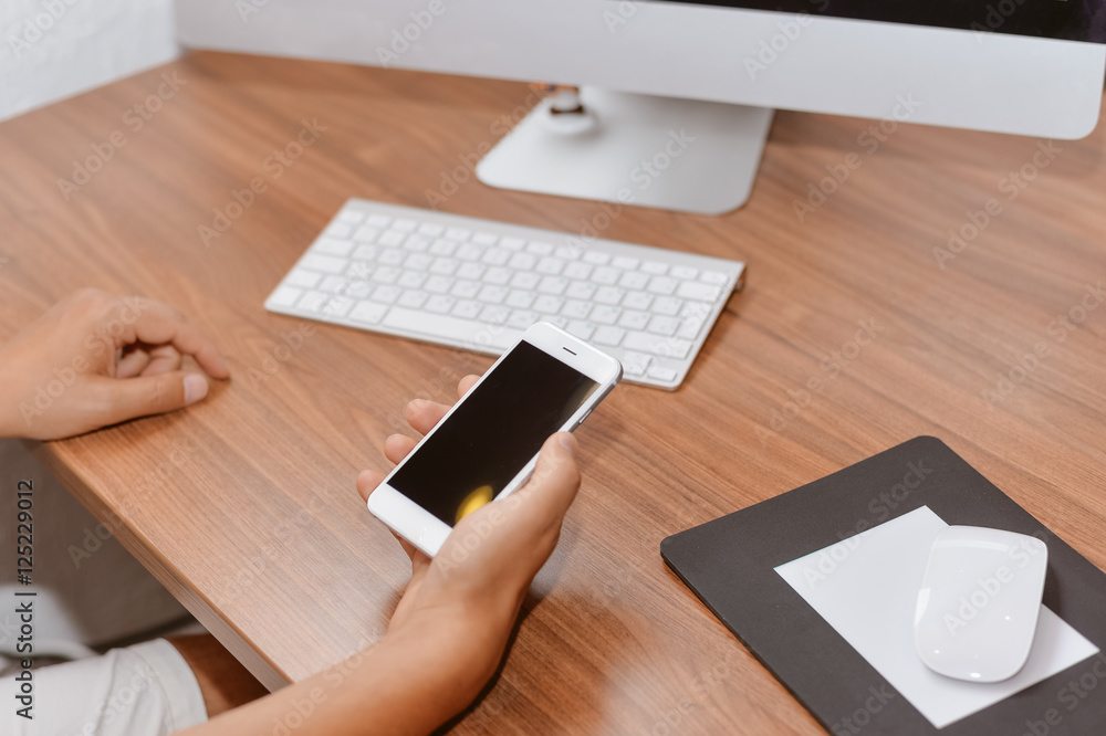 Top side view of a business person hands using smart phone, office desk ...