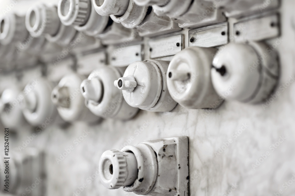 Ceramic switch and fuse groups on a vintage electrical switchboard in a ...