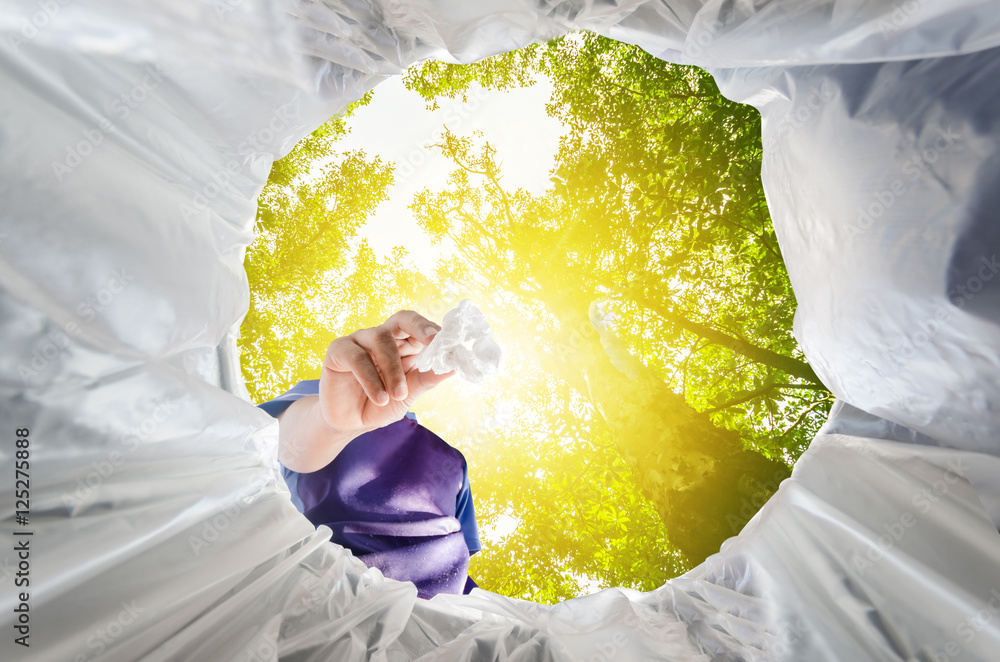 Man holding used tissue for recycling, viewed from inside recycling bin ...