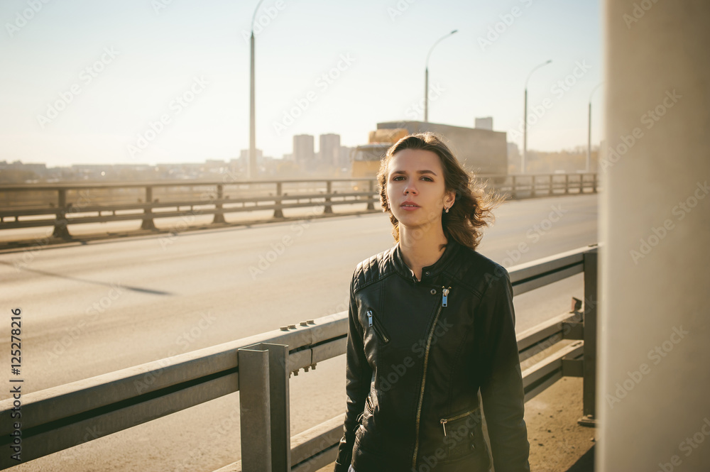 girl goes on road bridge. lonely young woman in black Leather jacket ...