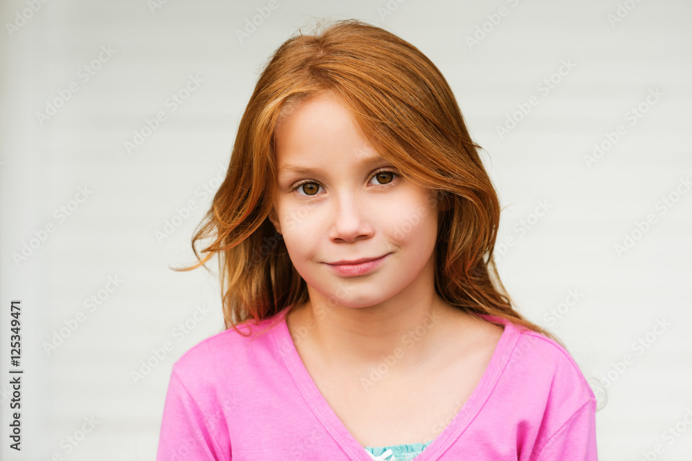 Outdoor portrait of cute little 8-9 year old girl with long red hair ...