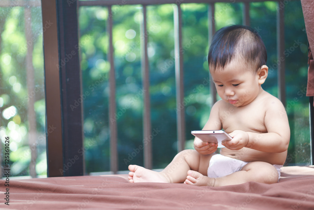 Asian baby playing mobile phone Stock Photo | Adobe Stock