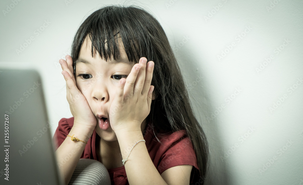 Asian girl shocked by what she see on computer screen. Content on the ...